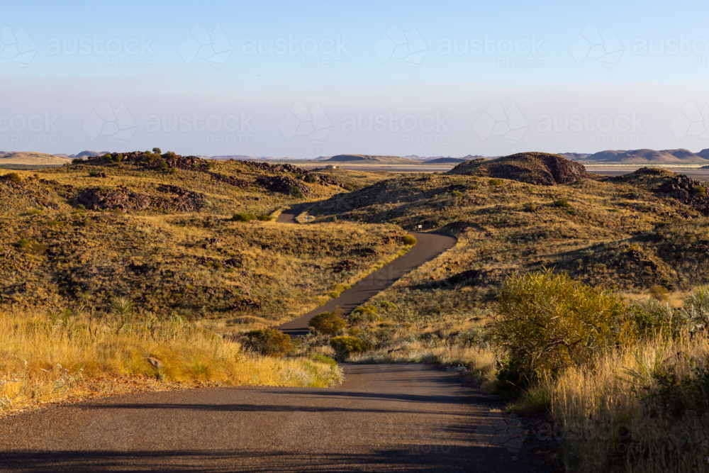 Image of pilbara landscape with winding sealed road leading through dry ...