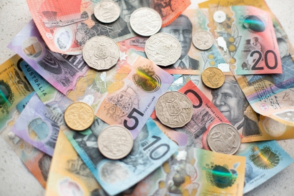 Image of pile of aussie notes and coins on a white benchtop background ...
