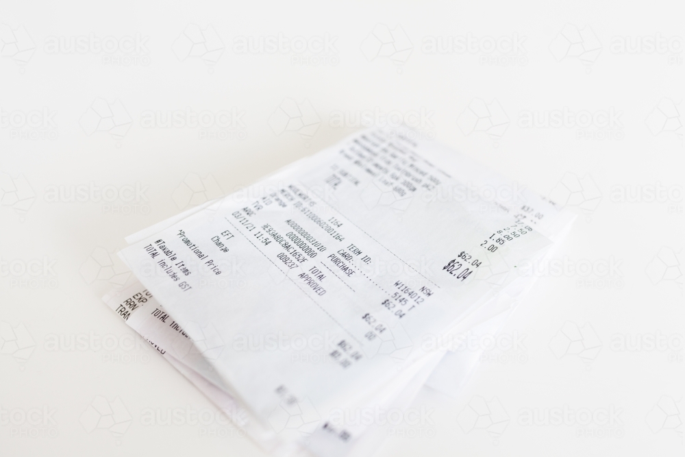 Image of Pile of paper shopping receipts on white - Austockphoto