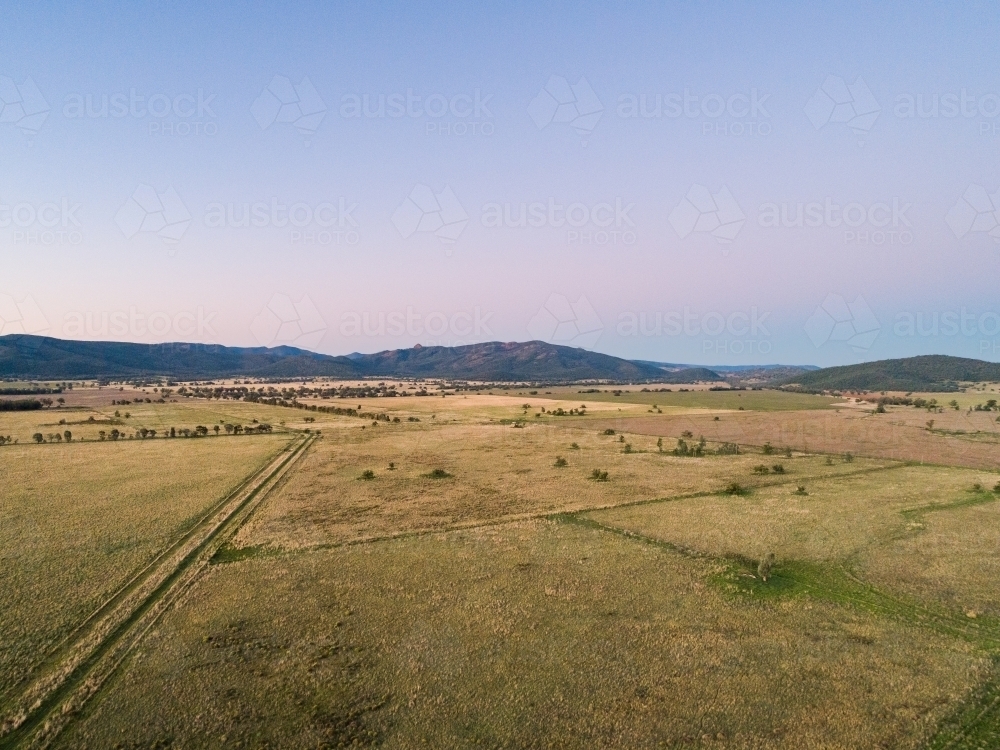 Image of pink dusk light over wide open spaces of pastoral farmland ...