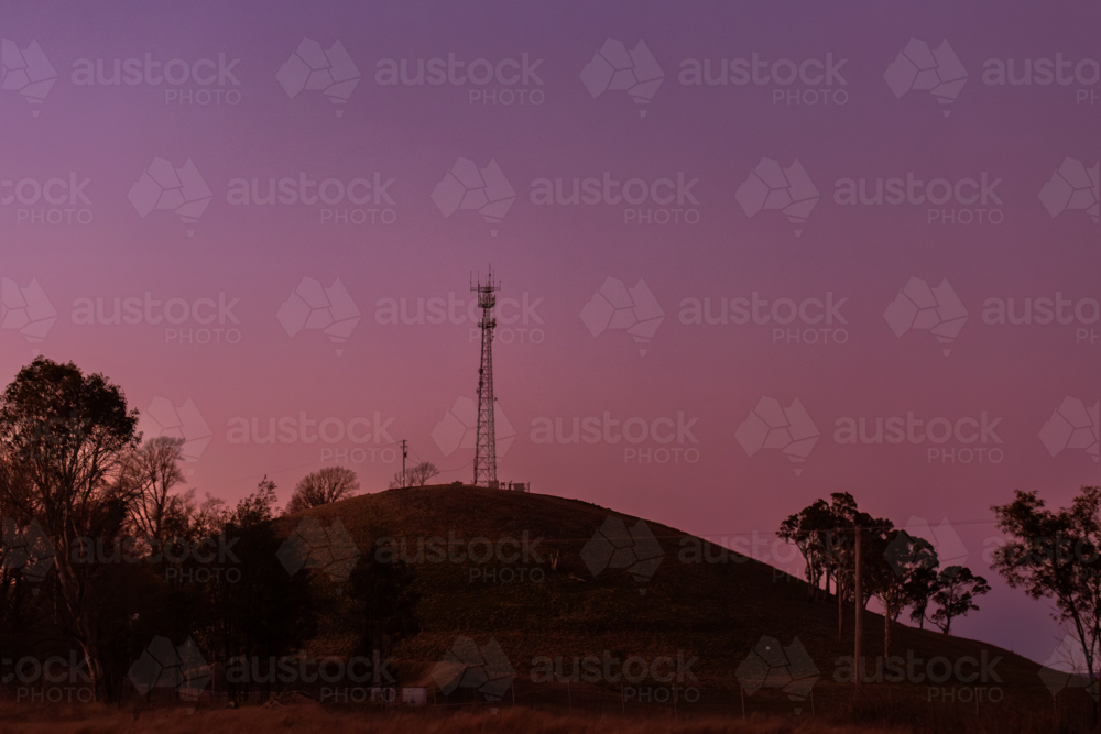 Image of pink dusk sky over farmland and hilltop with ...