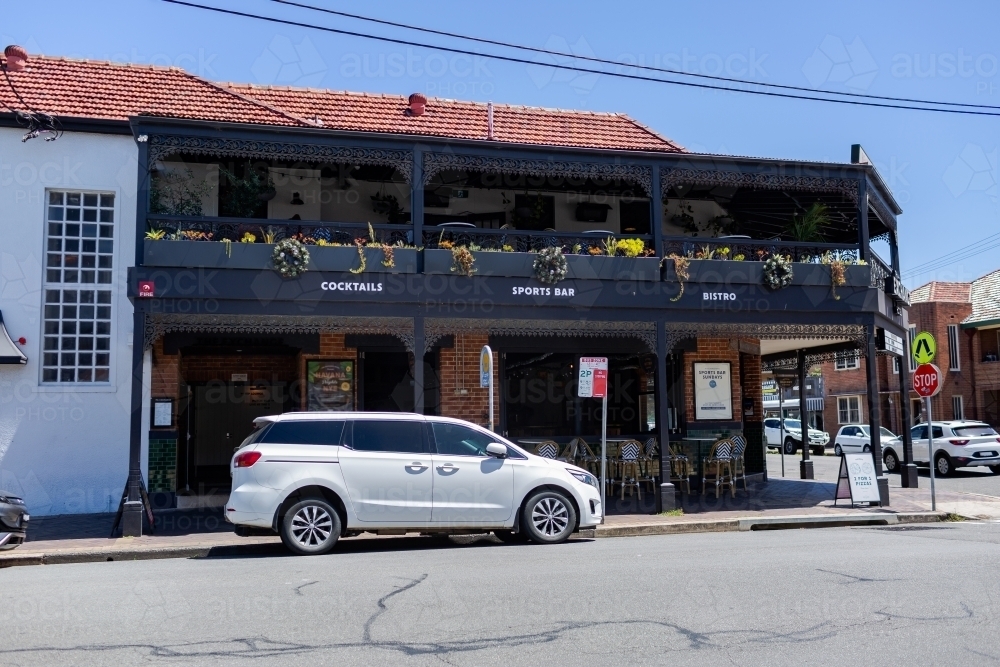 Image of Plants growing on veranda of pub on street corner with car ...