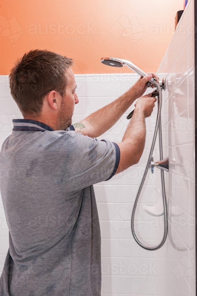 Image of Plumber installing a shower head and tap - Austockphoto
