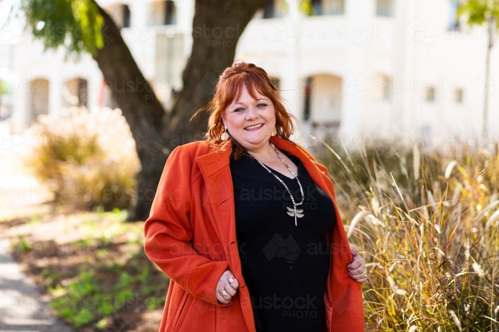 Image of portrait of a happy plus size woman smiling outside - Austockphoto