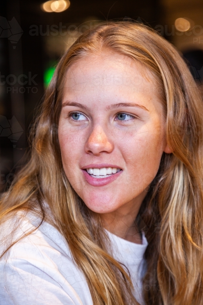 Image of Portrait of a happy young woman looking off camera talking ...