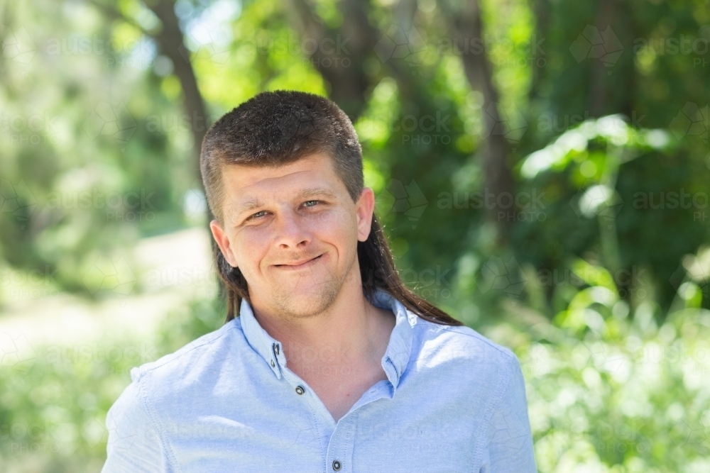 Image of Portrait of a man outside with a mullet hairstyle in a button ...