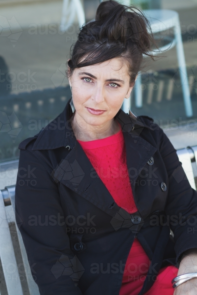 Image of Portrait of a serious professional woman on a park bench ...