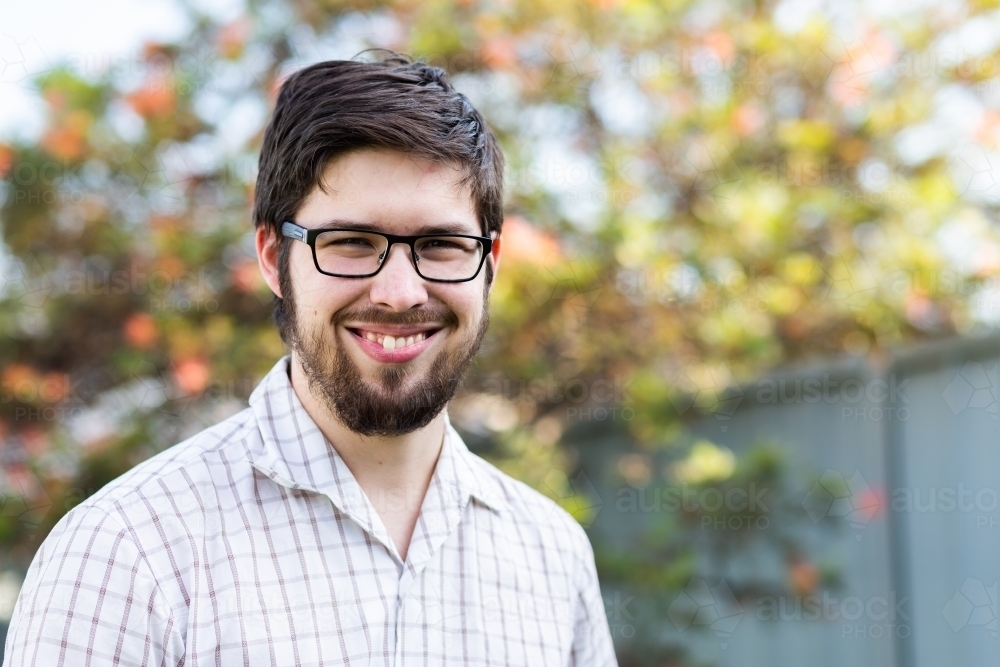 Image of Portrait of a smiling young man in his twenties - Austockphoto