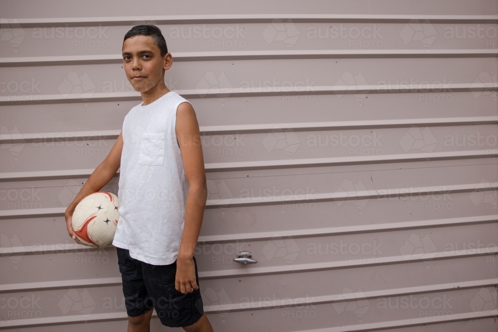 Image of Portrait of a young first nations boy holding a soccer ball ...