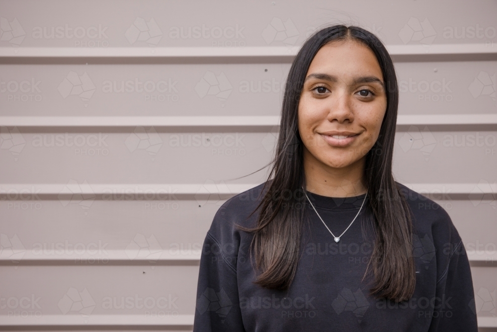Image of Portrait of a young, smiling, first nations woman against wall ...