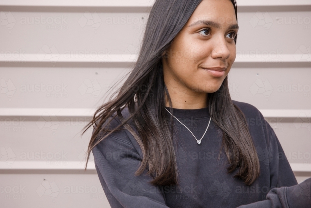 Image of Portrait of a young, smiling, first nations woman against wall ...