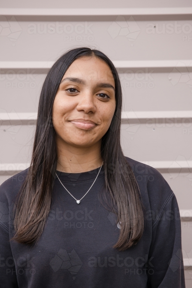 Image of Portrait of a young, smiling, first nations woman against wall ...