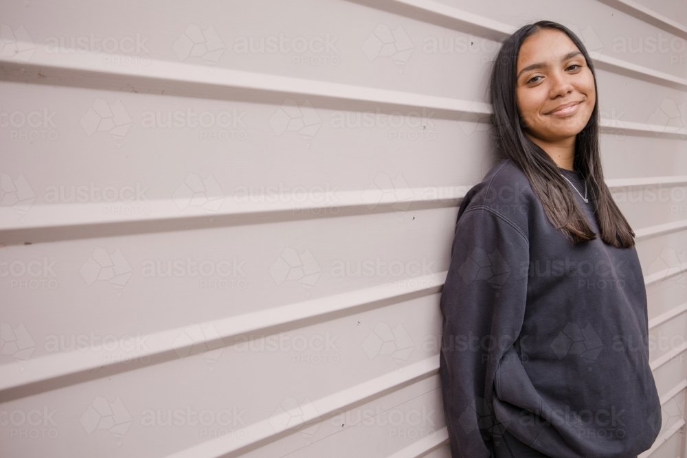Image of Portrait of a young, smiling, first nations woman against wall ...