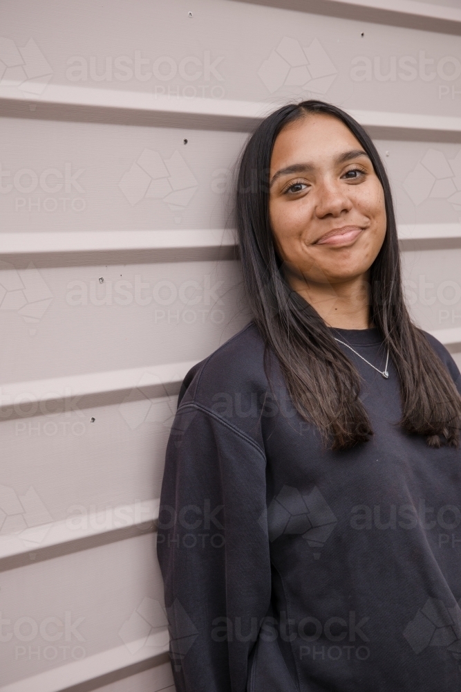 Image of Portrait of a young, smiling, first nations woman against wall ...