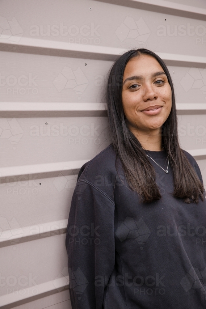Image of Portrait of a young, smiling, first nations woman against wall ...