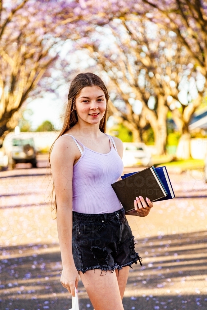 Image of Portrait of a young teenager with books outside - Austockphoto