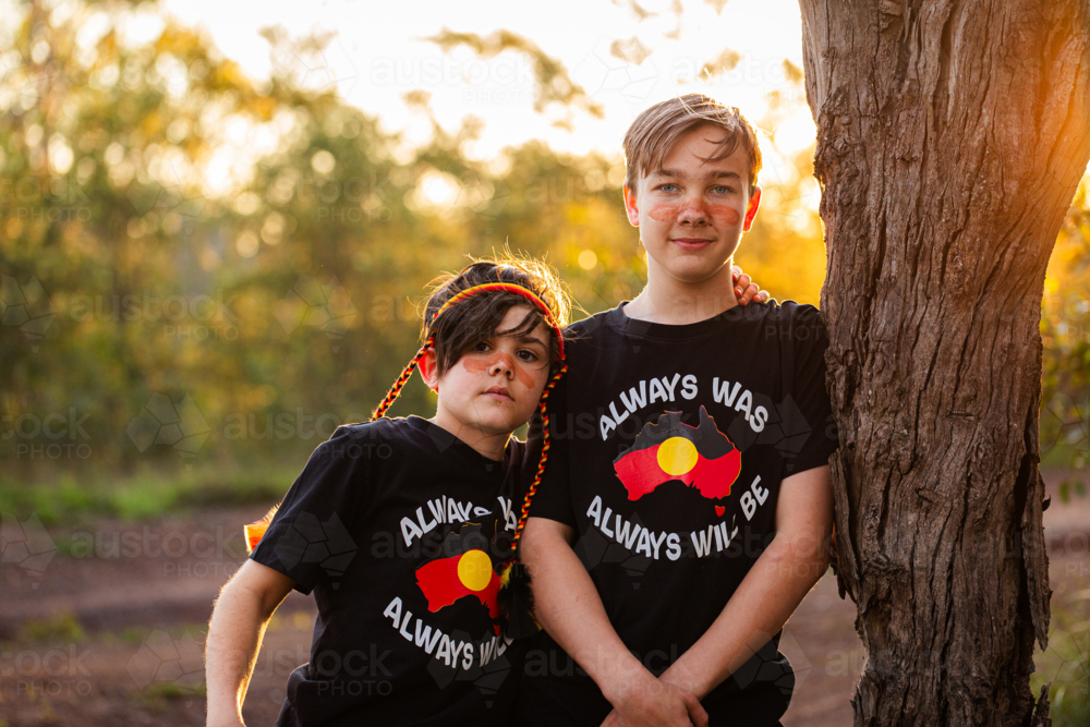 Image of Portrait of aboriginal brothers leaning against the tree in ...