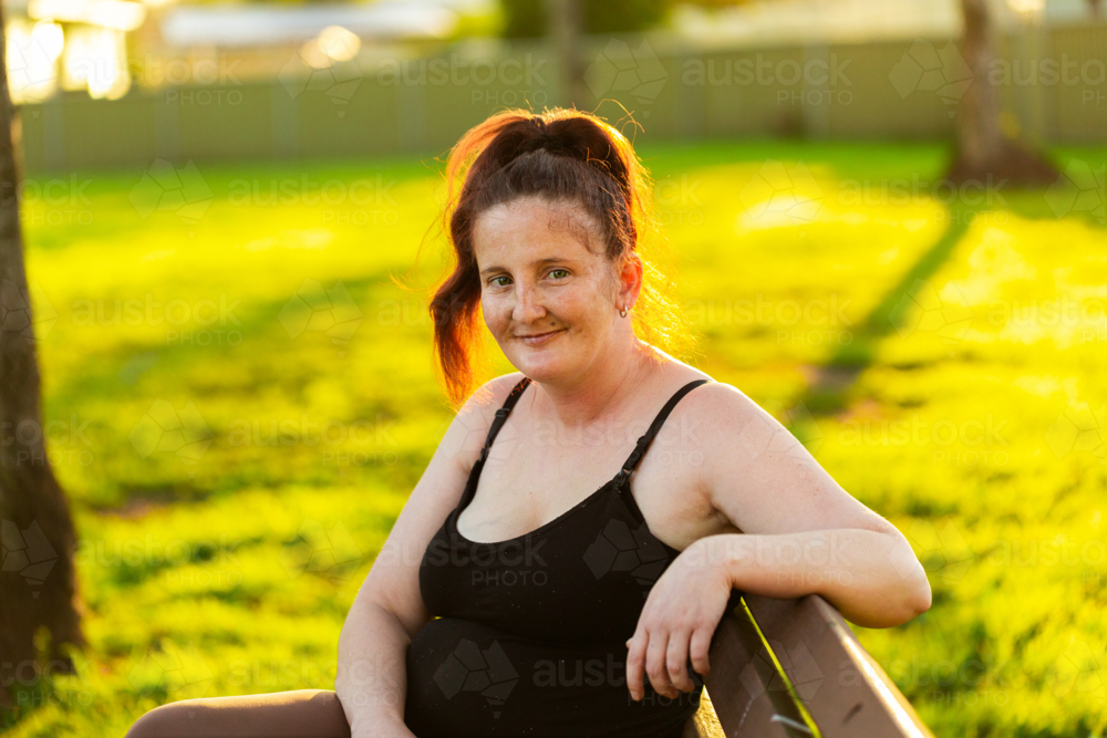 Image of Portrait of Aboriginal mum sitting on park bench - Austockphoto