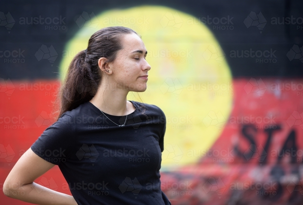Image of Portrait of an Aboriginal woman standing with a red, yellow ...