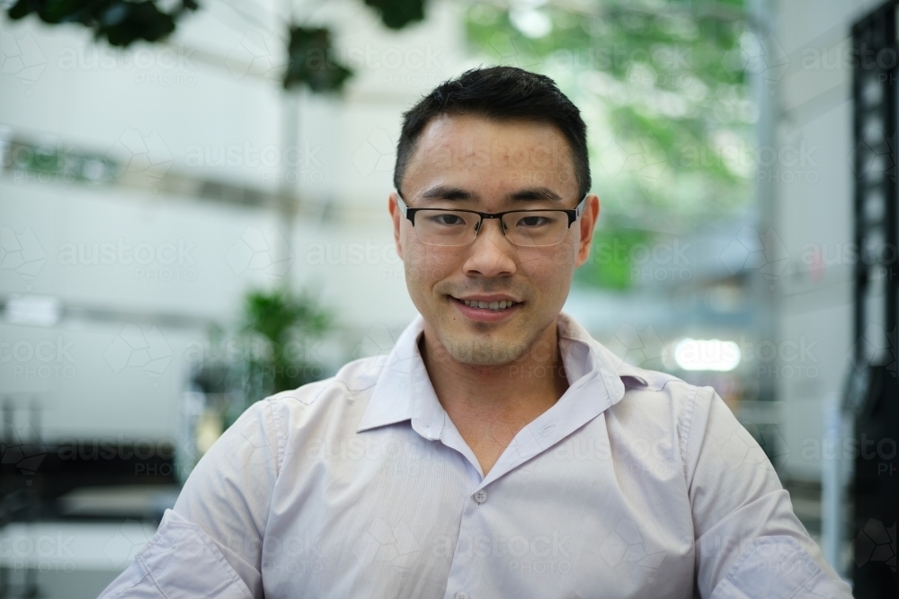 Image of Portrait of Asian man in modern workplace smiling - Austockphoto