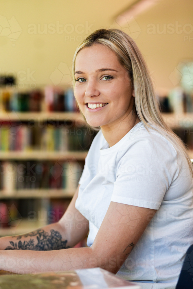 Image of portrait of first nations Australian woman sitting at library ...