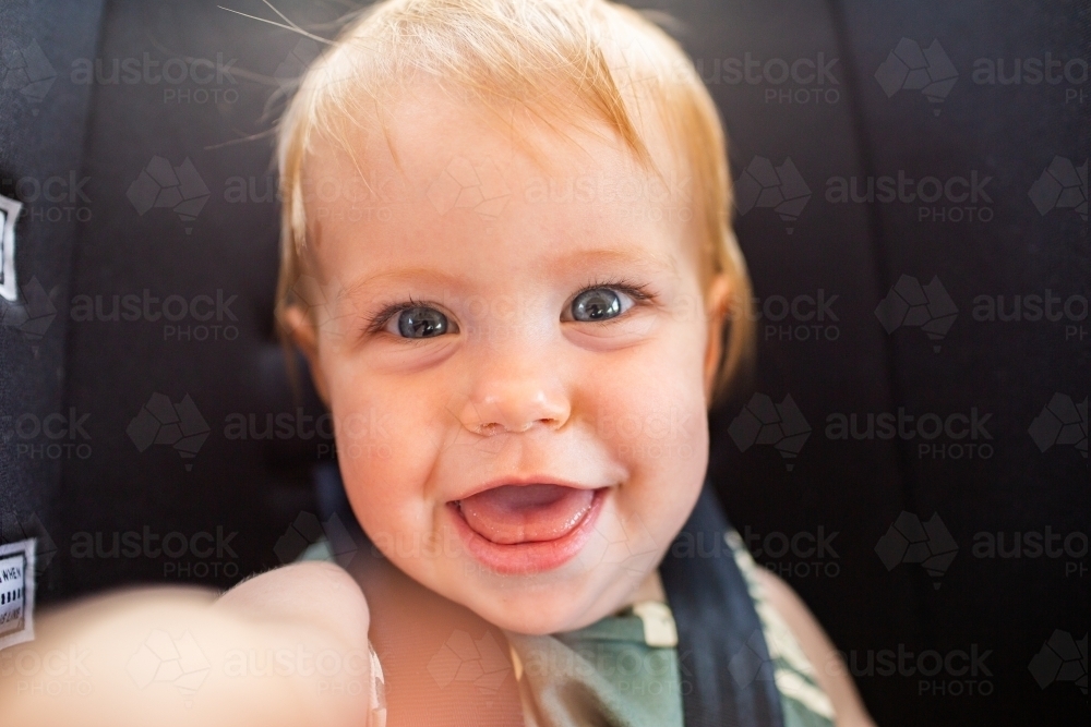 Image of portrait of happy aussie baby girl in car seat - Austockphoto