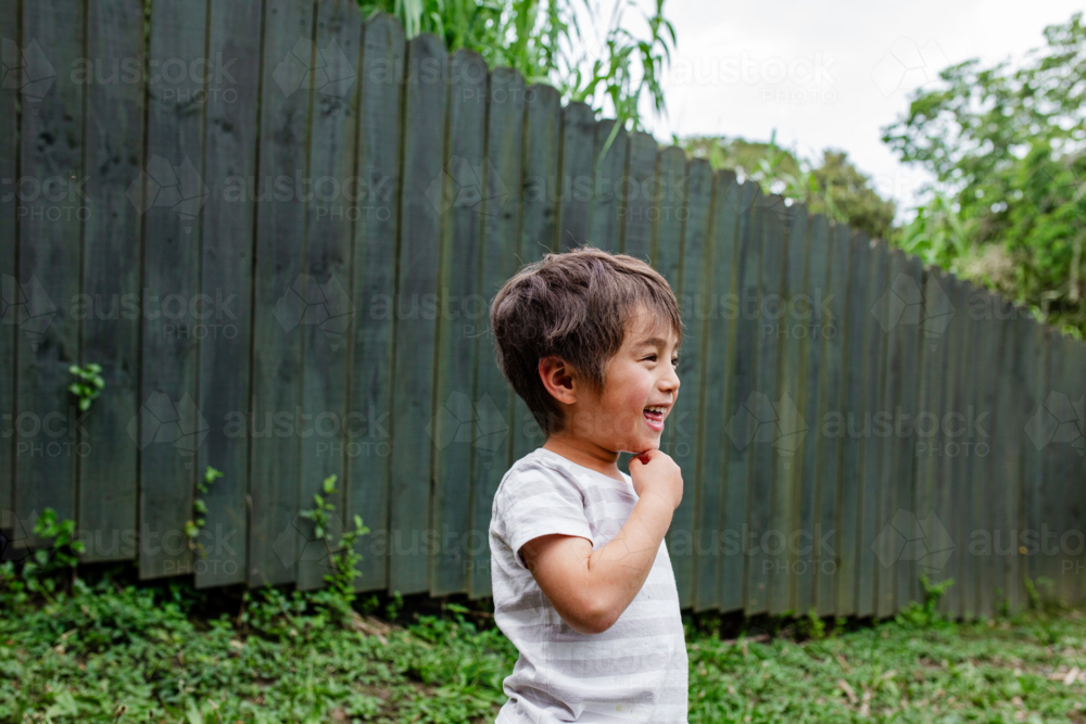 Image of Portrait of happy boy in backyard - Austockphoto