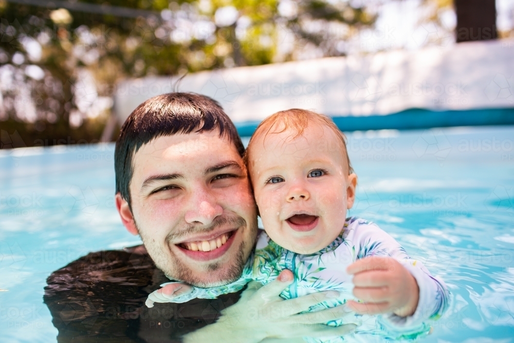 Image of Portrait of Happy dad and baby in swimming pool together ...