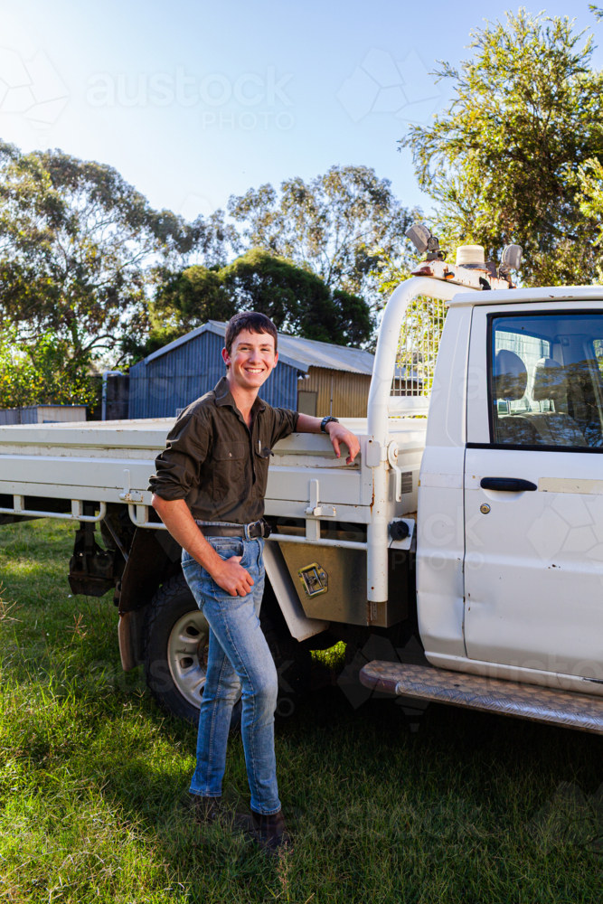 Image of Portrait of happy smiling teenaged young man standing by ute ...