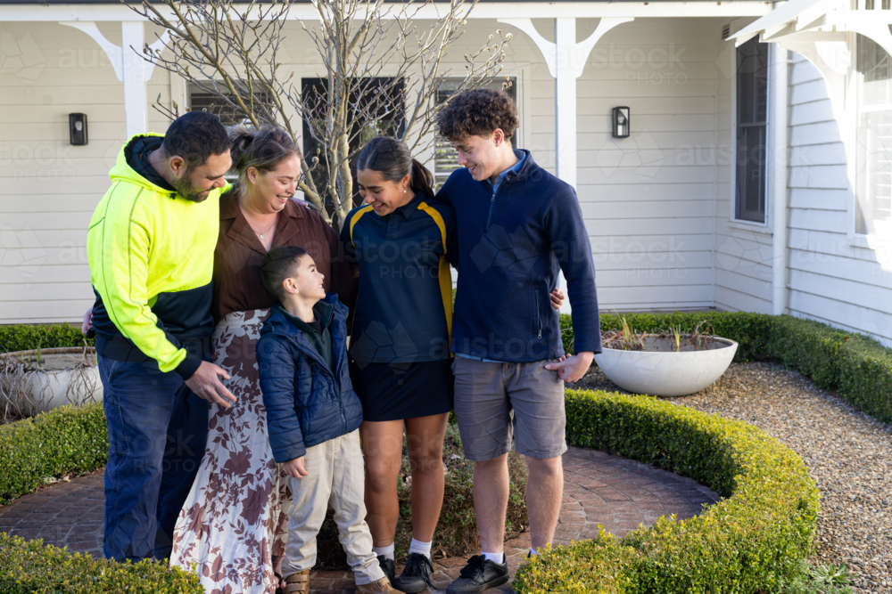 Image of Portrait of mixed ethnicity family standing on brick pathway ...