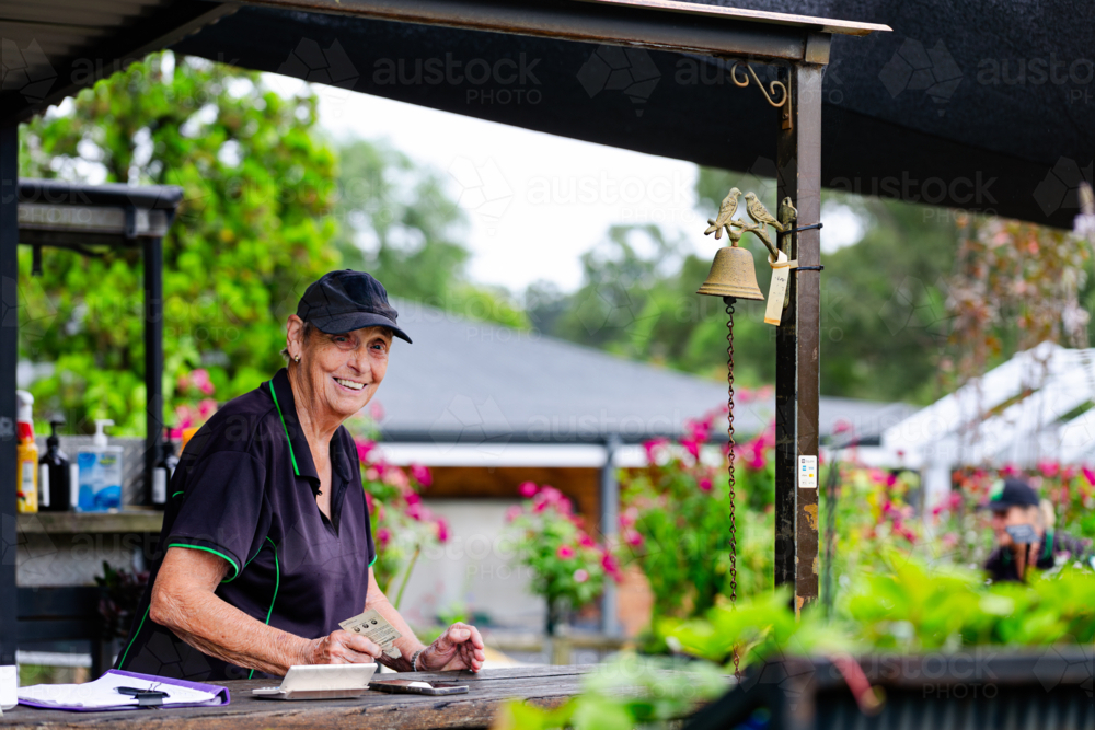 Image of Portrait of senior woman working at shop counter of small ...
