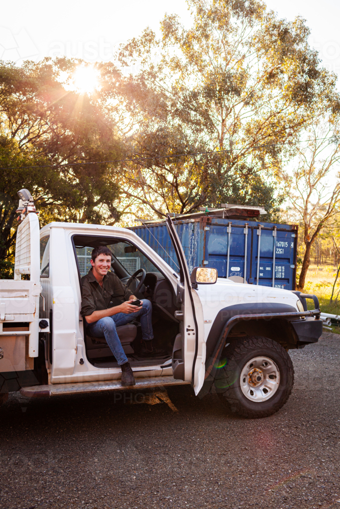 Image of Portrait of smiling teenaged young man sitting in his ute ...