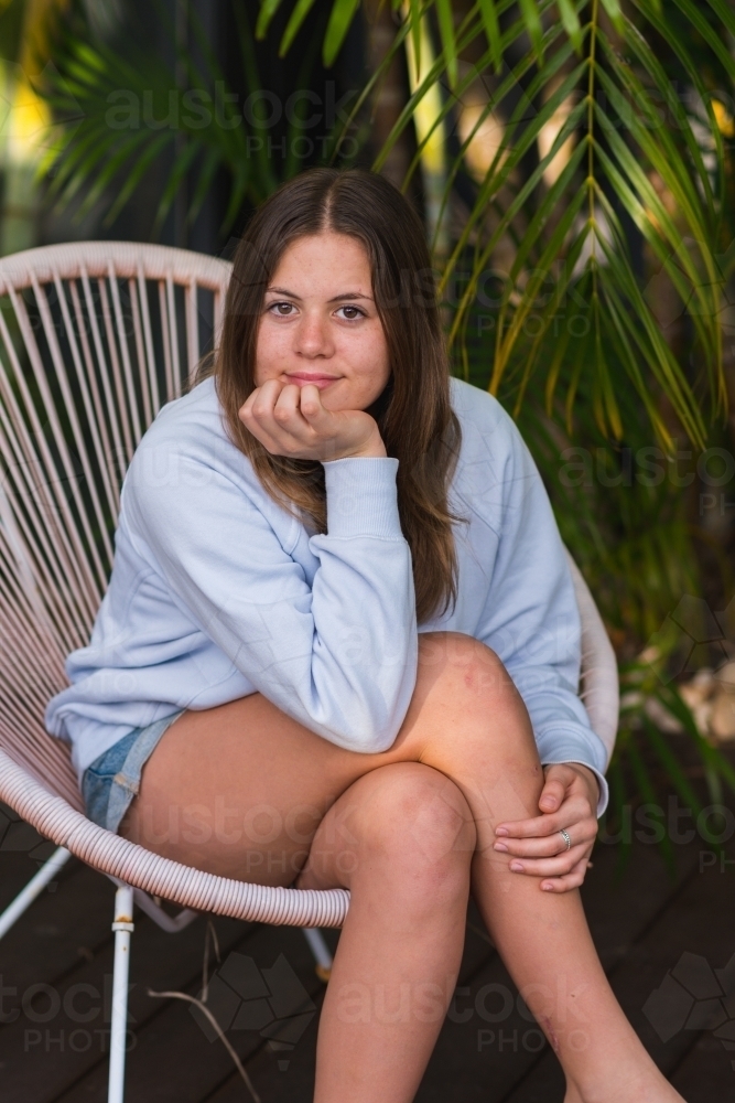 Image of portrait of teen girl, sitting on chair outdoors - Austockphoto