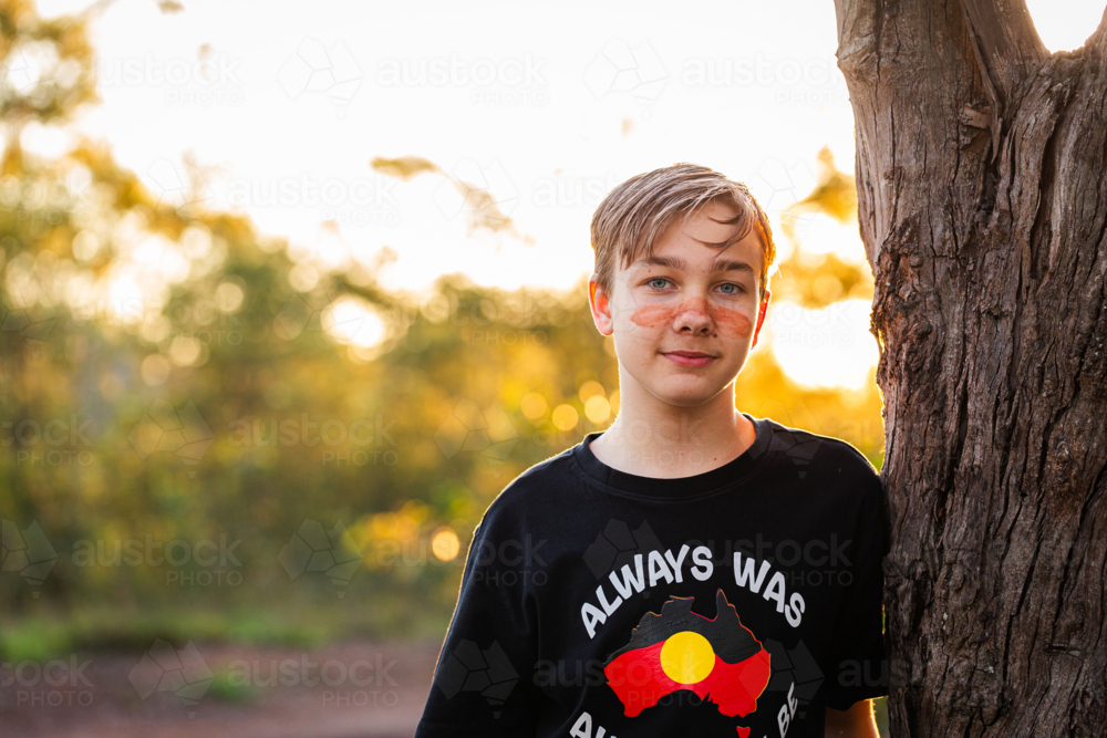 Image of Portrait of teenaged aboriginal boy smiling by tree in ...