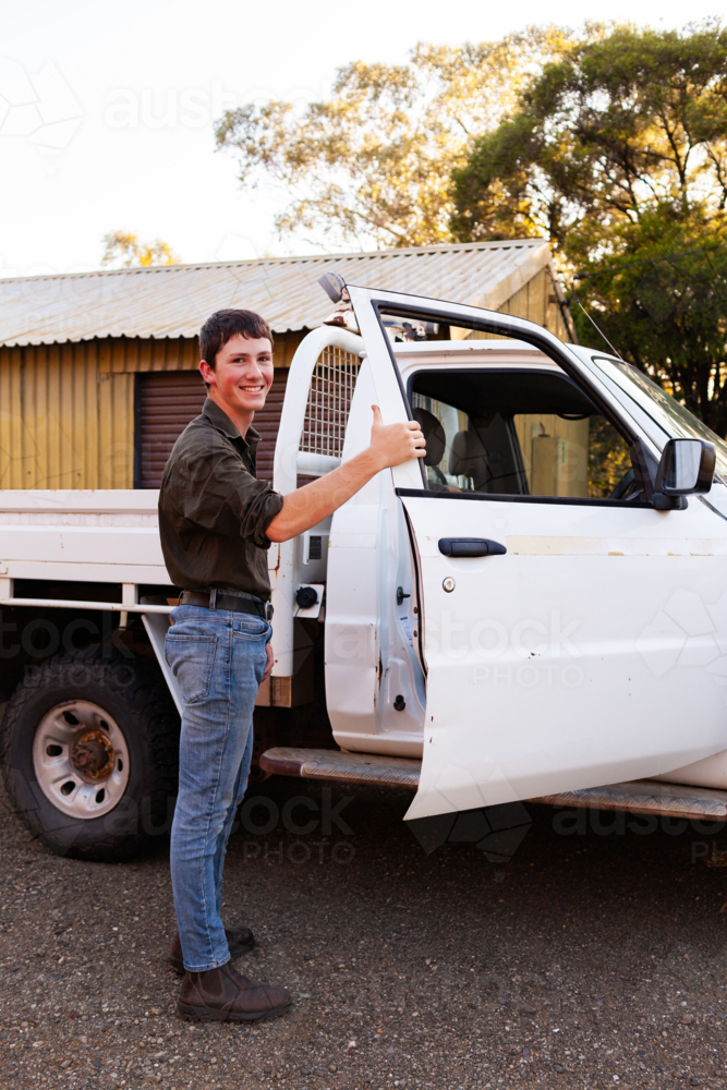 Image of Portrait of teenaged young man standing with his first car a ...