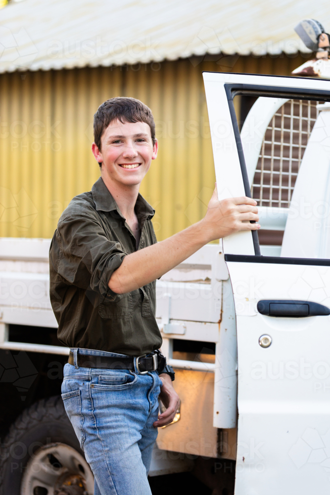 Image of Portrait of teenaged young man standing with his first car a ...
