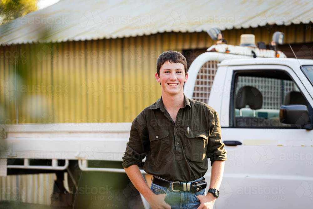 Image of Portrait of teenaged young man standing with his first car a ...