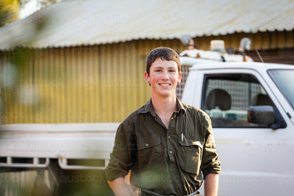 Image of Portrait of teenaged young man standing with his first car a ...