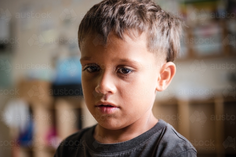 Image of Portrait of young Aboriginal boy looking sad - Austockphoto