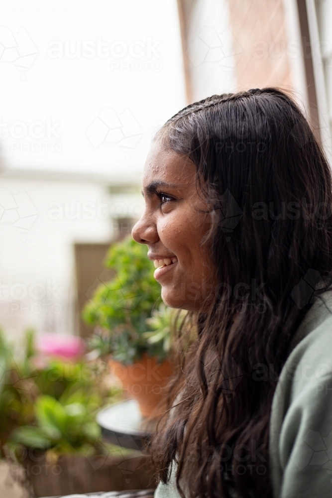 Image of Portrait of young Aboriginal woman sitting outside - Austockphoto