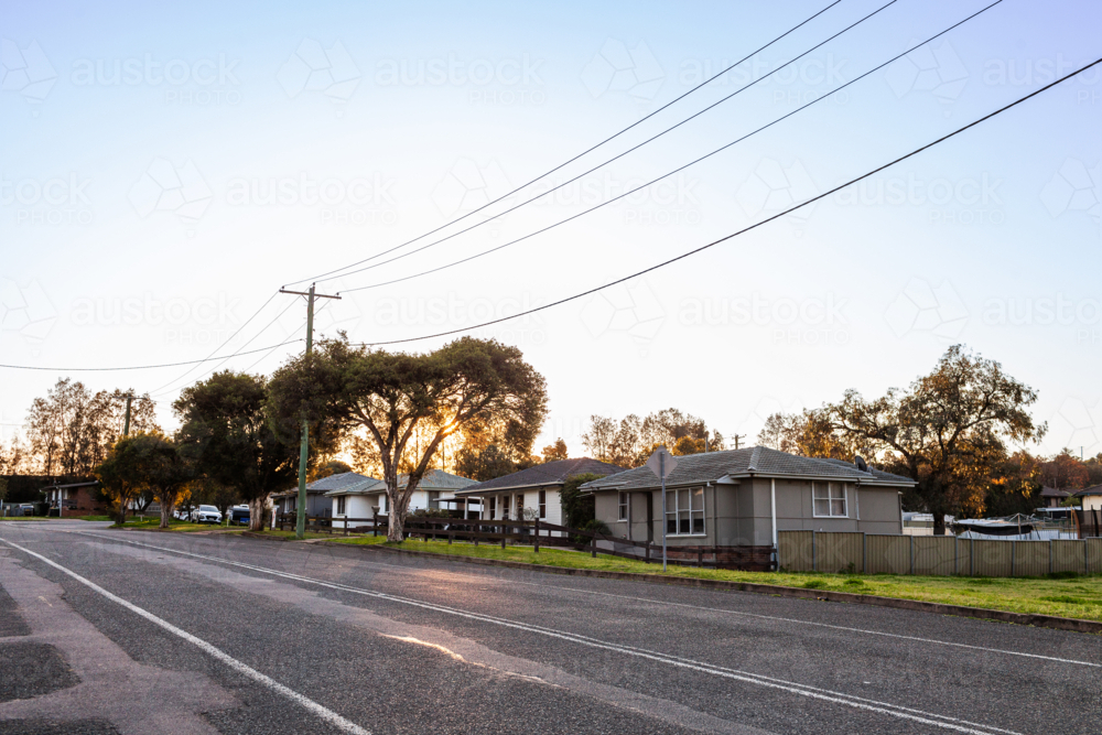 Image of Powerline above houses along suburban street at dusk ...