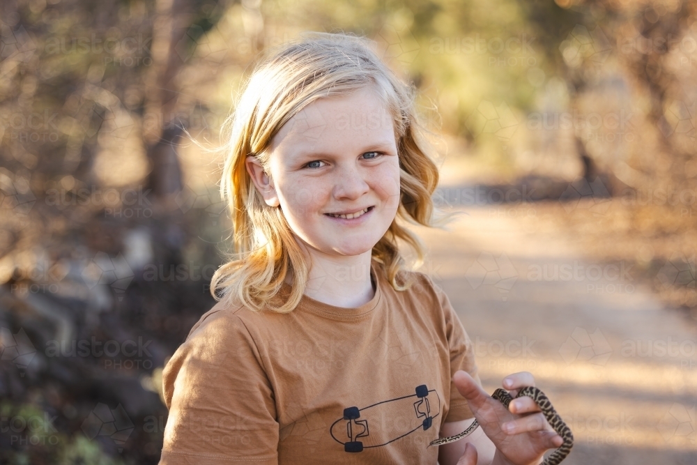 Image of Pre-teen adolescent boy holding pet children's python snake ...