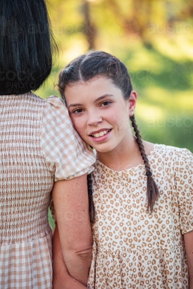 Image of Pre-teen girl leaning on mothers shoulder in natural bush ...