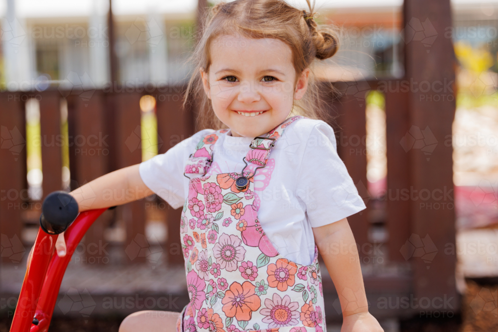 Image of Preschool child riding bike in kindergarten yard - Austockphoto