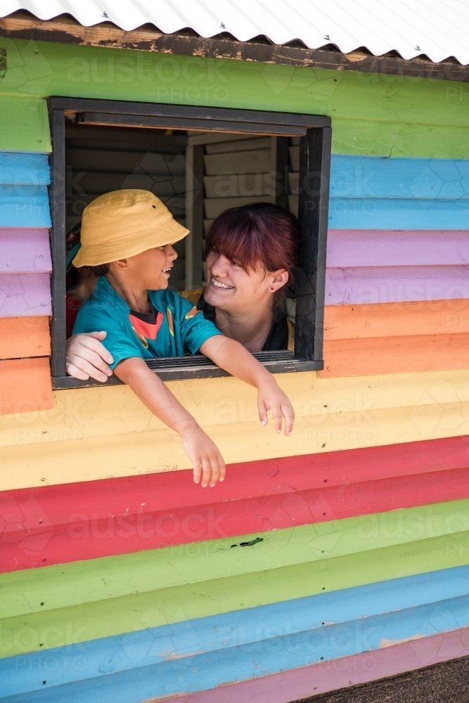Image of Preschool educator with young Aboriginal boy in cubby house ...