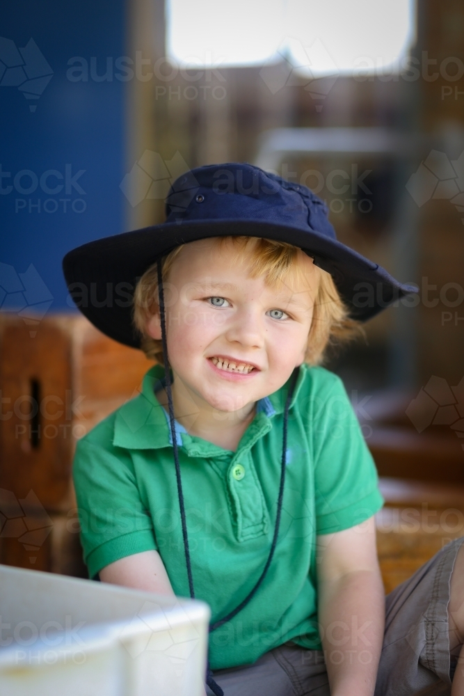 Image of Preschooler wearing blue hat at kindergarten - Austockphoto