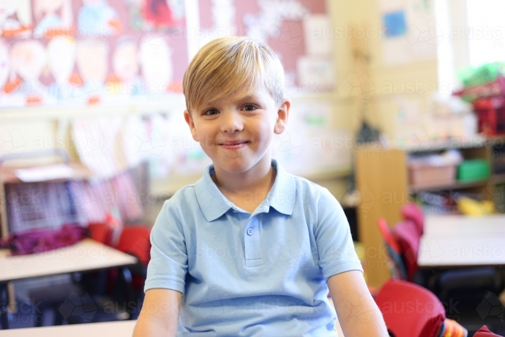 Image of Primary age boy in classroom, smiling at camera - Austockphoto