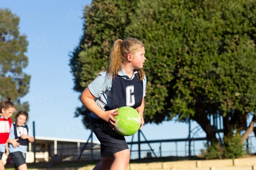 Image of Primary school child with hearing aid playing netball ...
