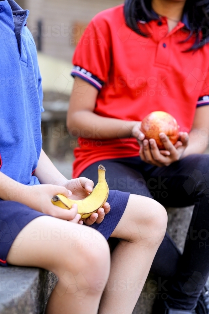 Image of primary school student holding healthy banana for fruit break ...