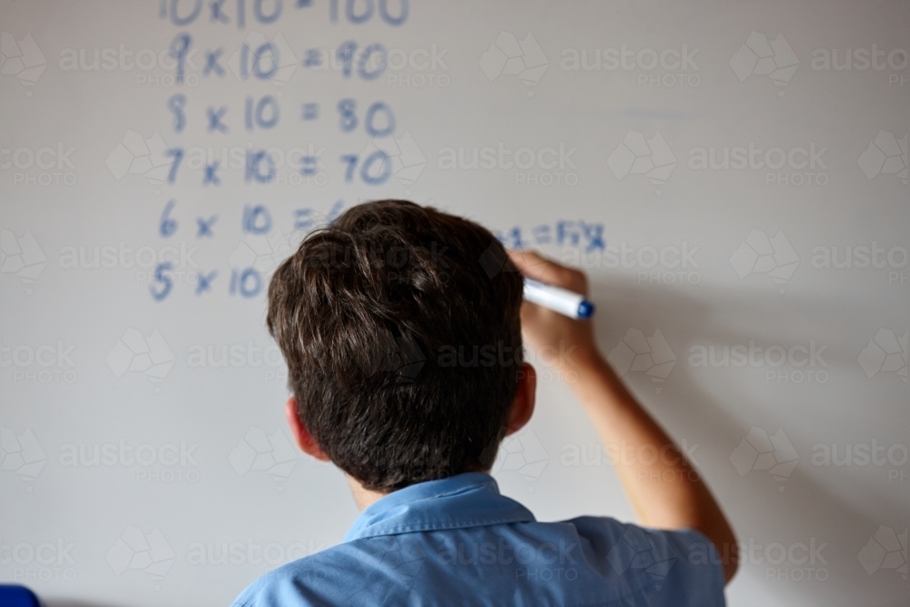 Image of Primary school student writing on whiteboard - Austockphoto